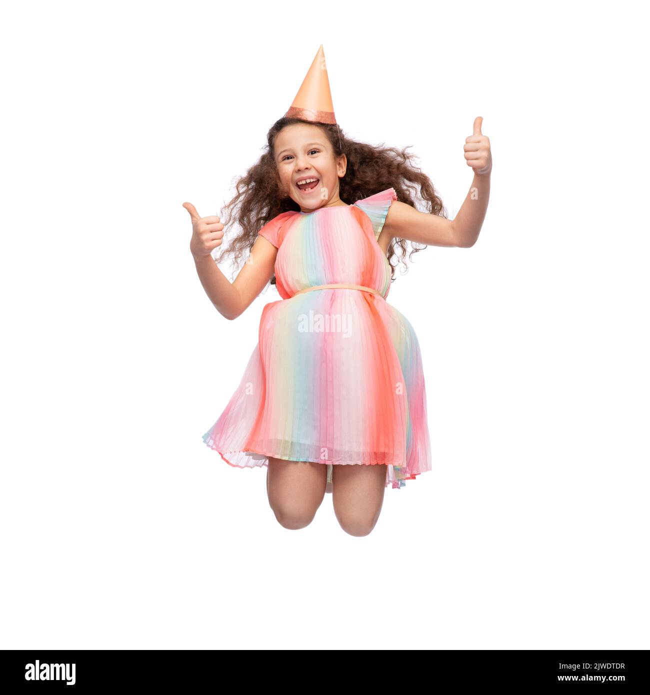 smiling little girl in birthday party hat jumping Stock Photo - Alamy