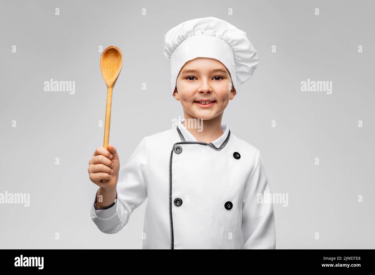 smiling little boy in chef's toque with spoon Stock Photo - Alamy