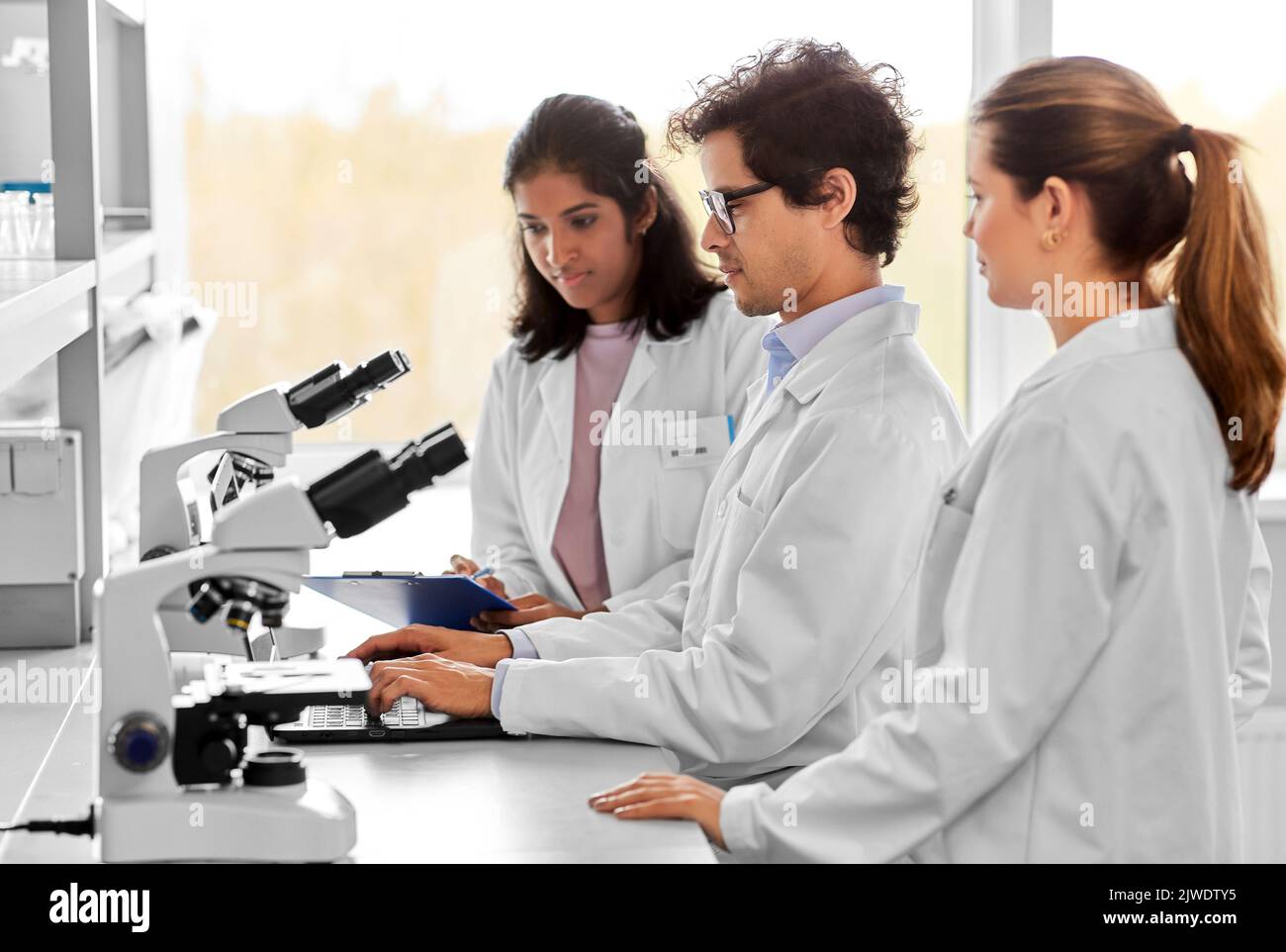 scientists with microscopes working in laboratory Stock Photo - Alamy