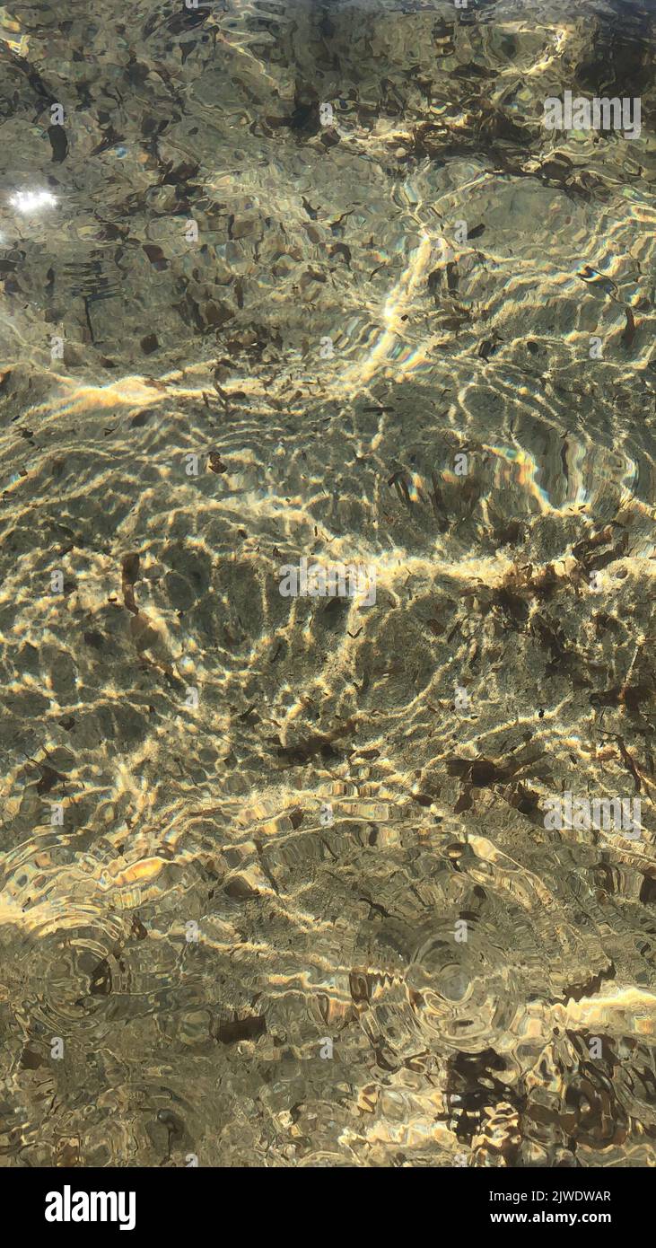 Water reflection texture on the beach sand. Clean transparent water and ...