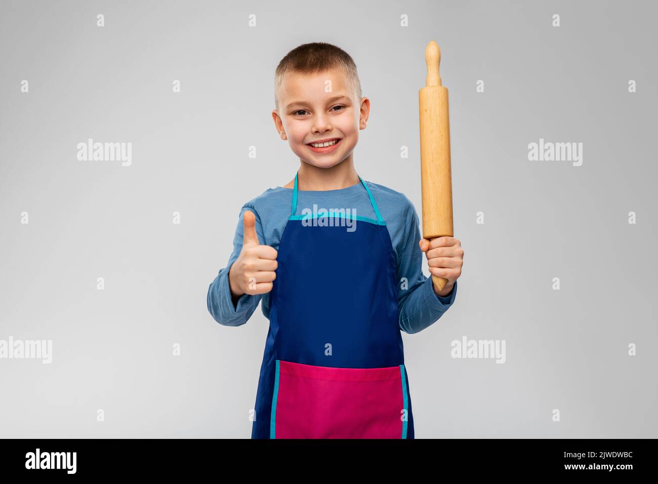 boy in apron with rolling pin showing thumbs up Stock Photo - Alamy