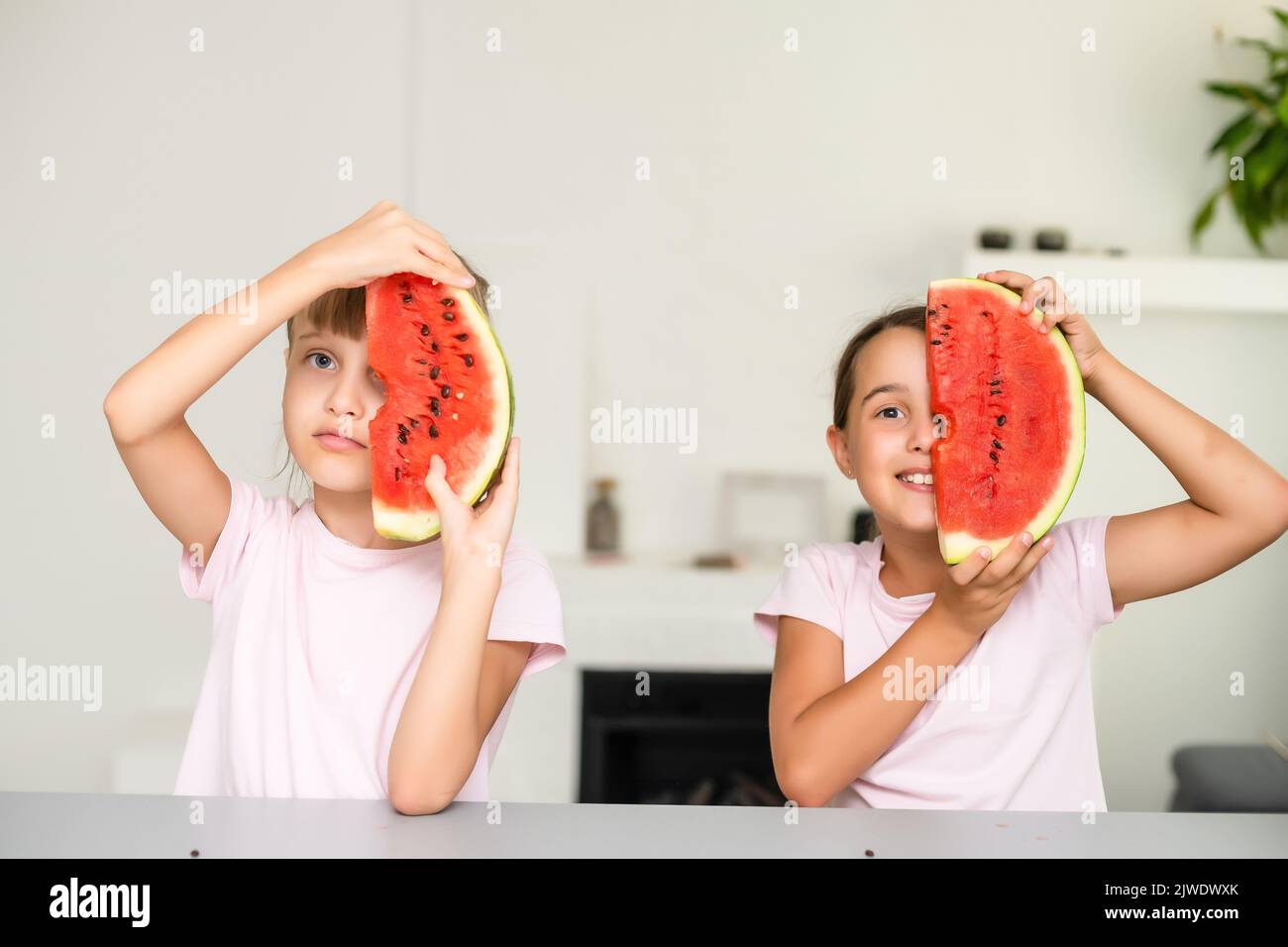 Funny little sisters eating fresh juicy watermelon at home Stock Photo ...
