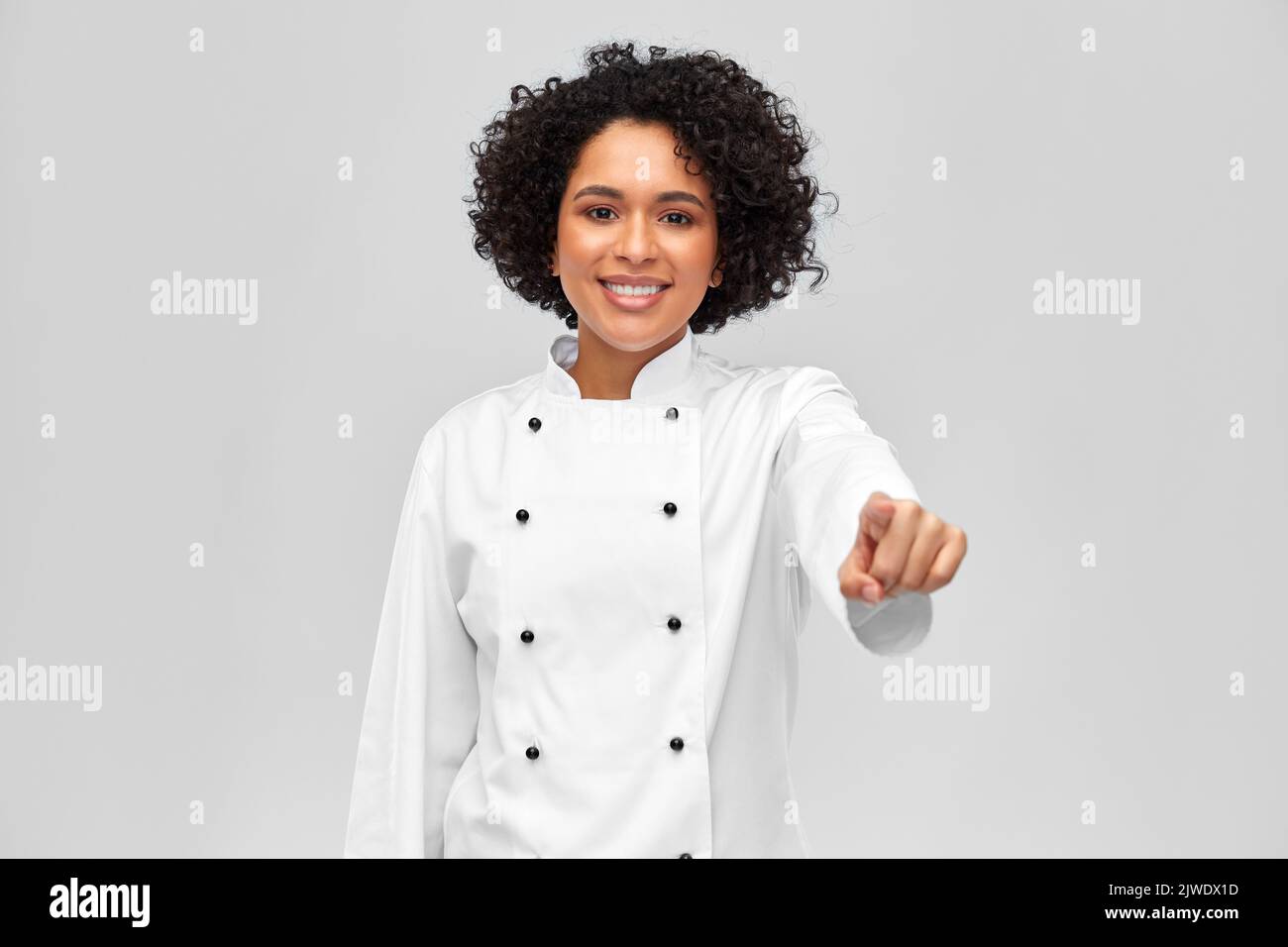 smiling female chef pointing finger to sonething Stock Photo - Alamy
