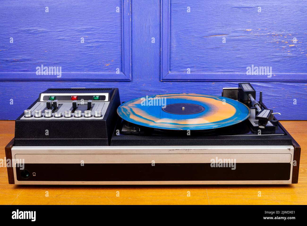 Vintage turntable vinyl record player with blue and orange vinyl on a ...