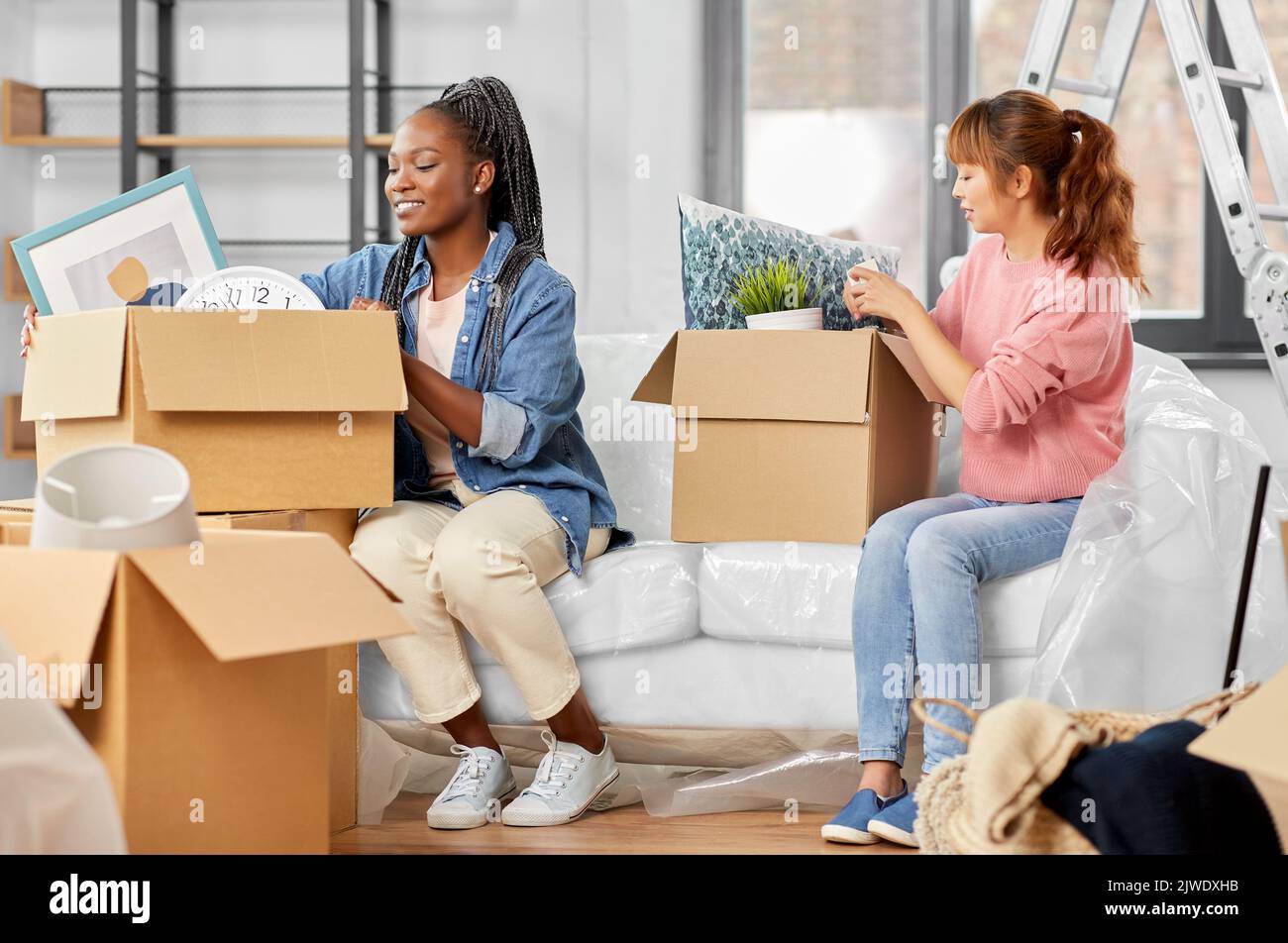 women unpacking boxes and moving to new home Stock Photo - Alamy