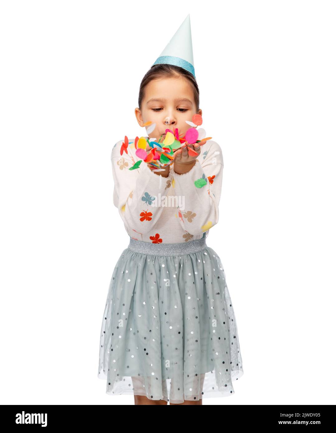 girl in birthday party hat blowing to confetti Stock Photo - Alamy