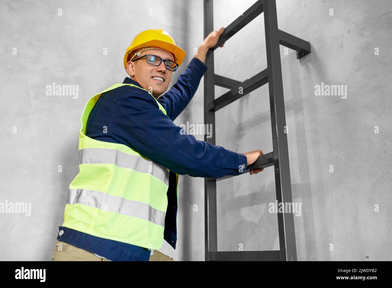 builder or worker in helmet climbing ladder Stock Photo - Alamy