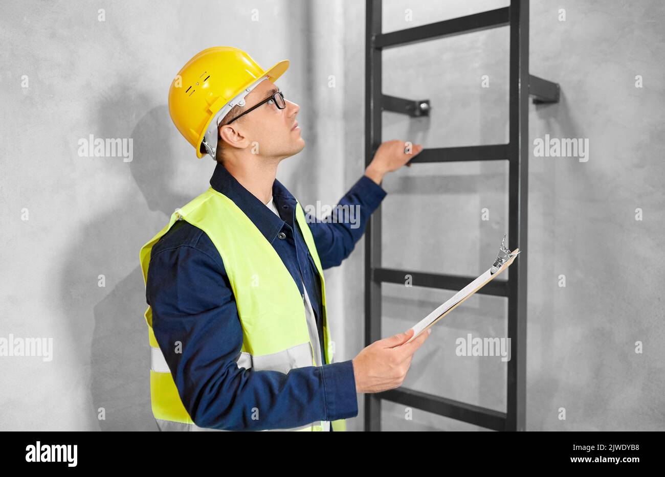 builder or worker with clipboard at ladder Stock Photo - Alamy