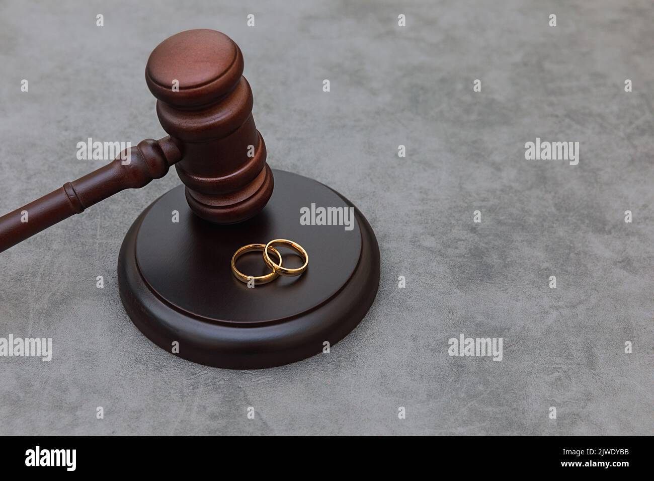 Law theme. Judge gavel wedding rings on concrete stone grey background ...