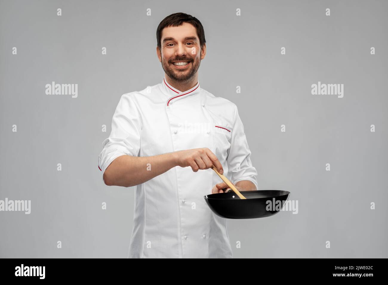 happy smiling male chef cooking food on frying pan Stock Photo - Alamy