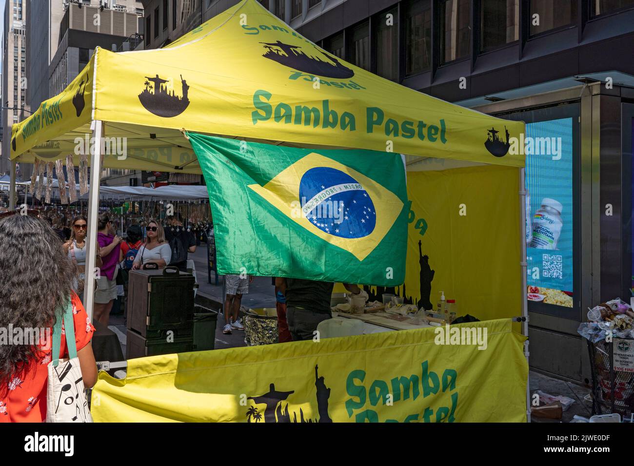 People wearing Brazilian shirts and flags enjoy a street fair on Sixth ...
