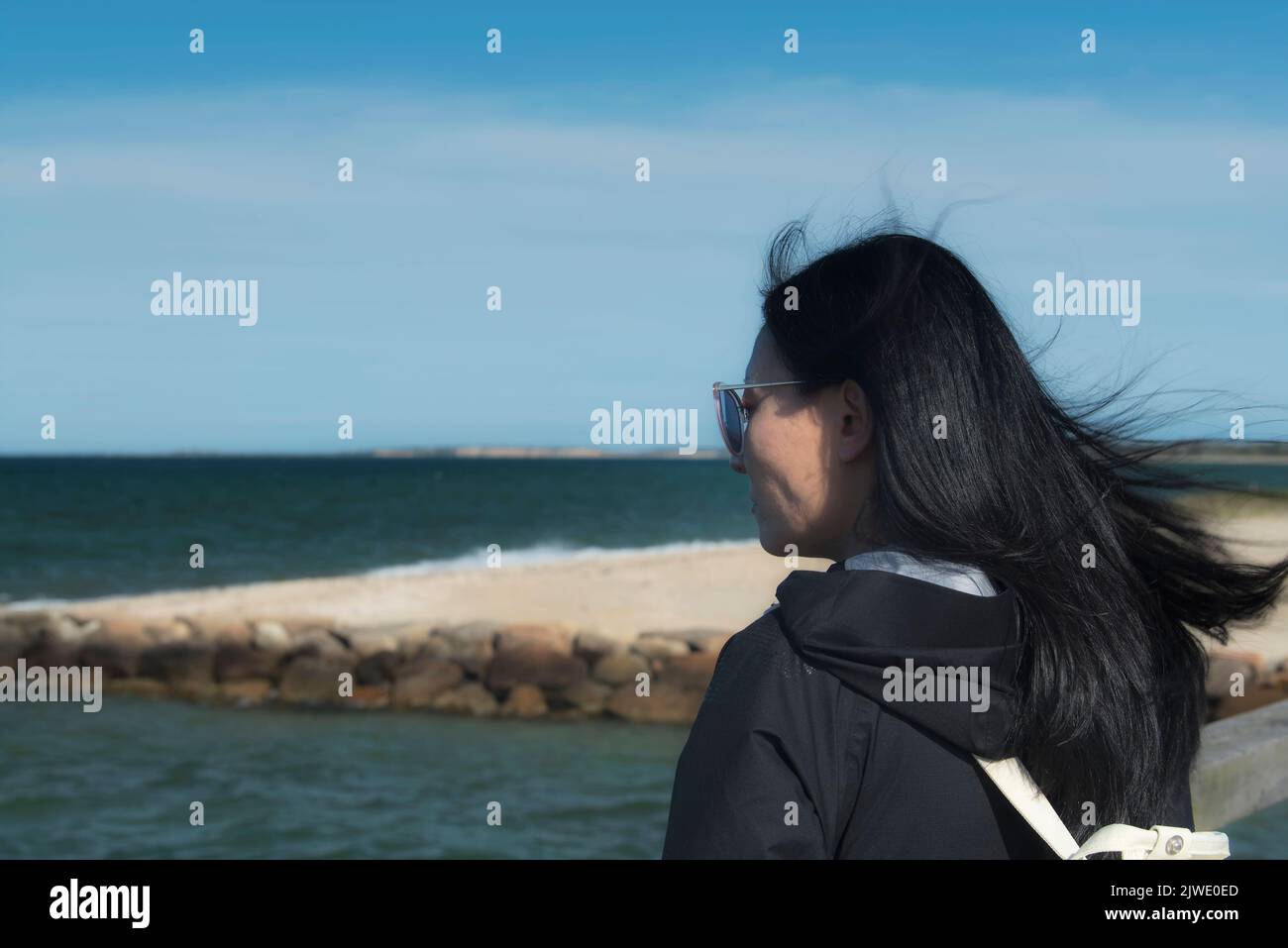 A sad chinese woman looking out over the atlantic ocean in oak bluffs ...