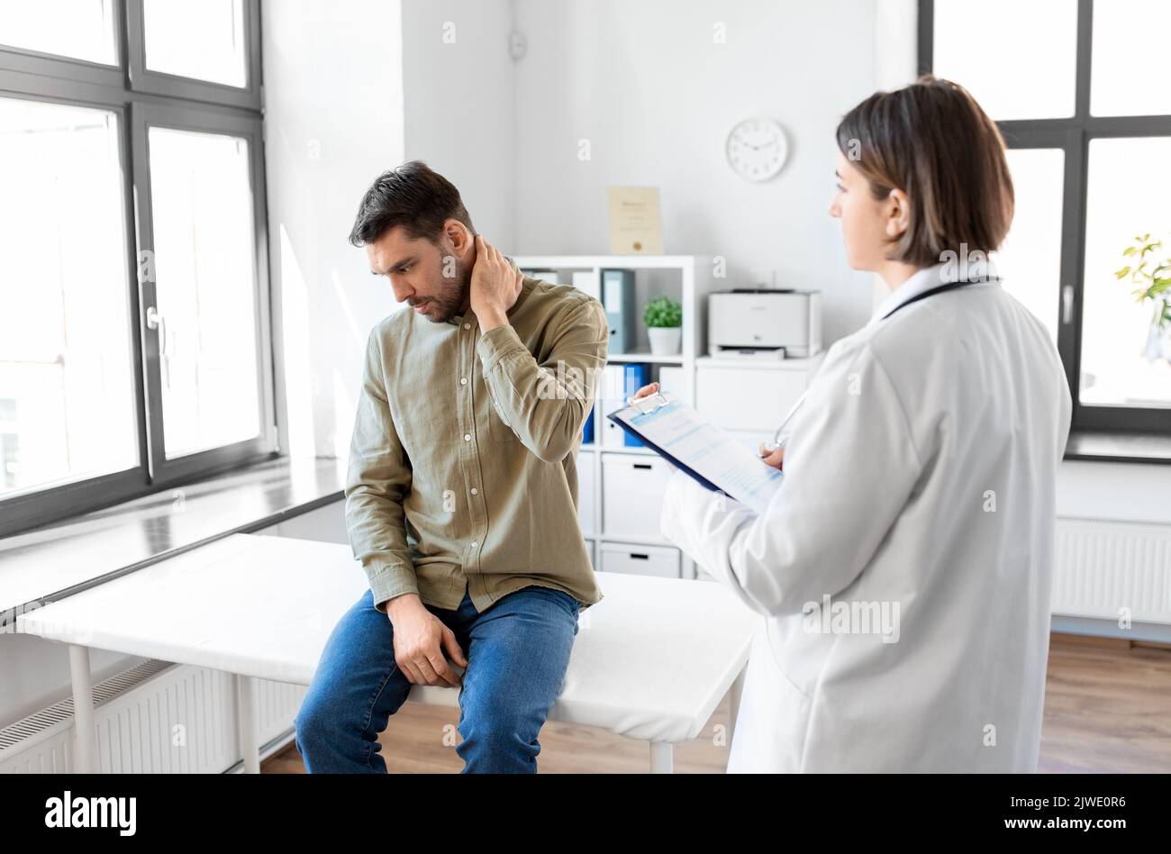 patient with pain in neck and doctor at hospital Stock Photo - Alamy