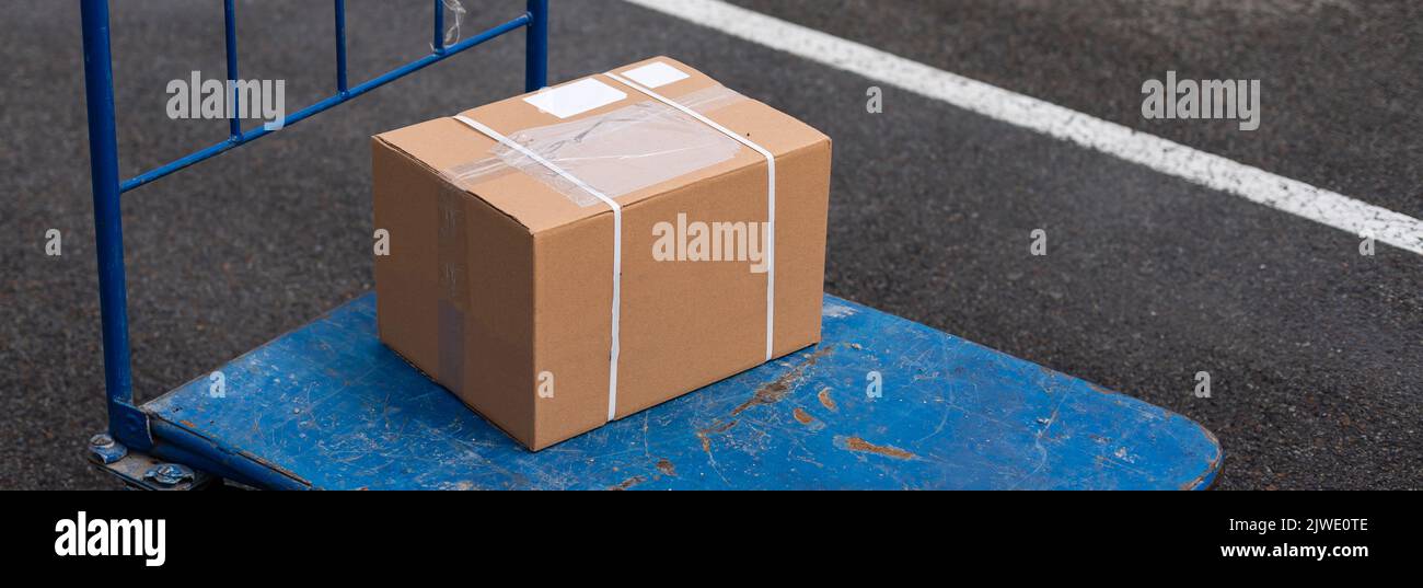 Brown cardboard moving box in the cart Stock Photo - Alamy