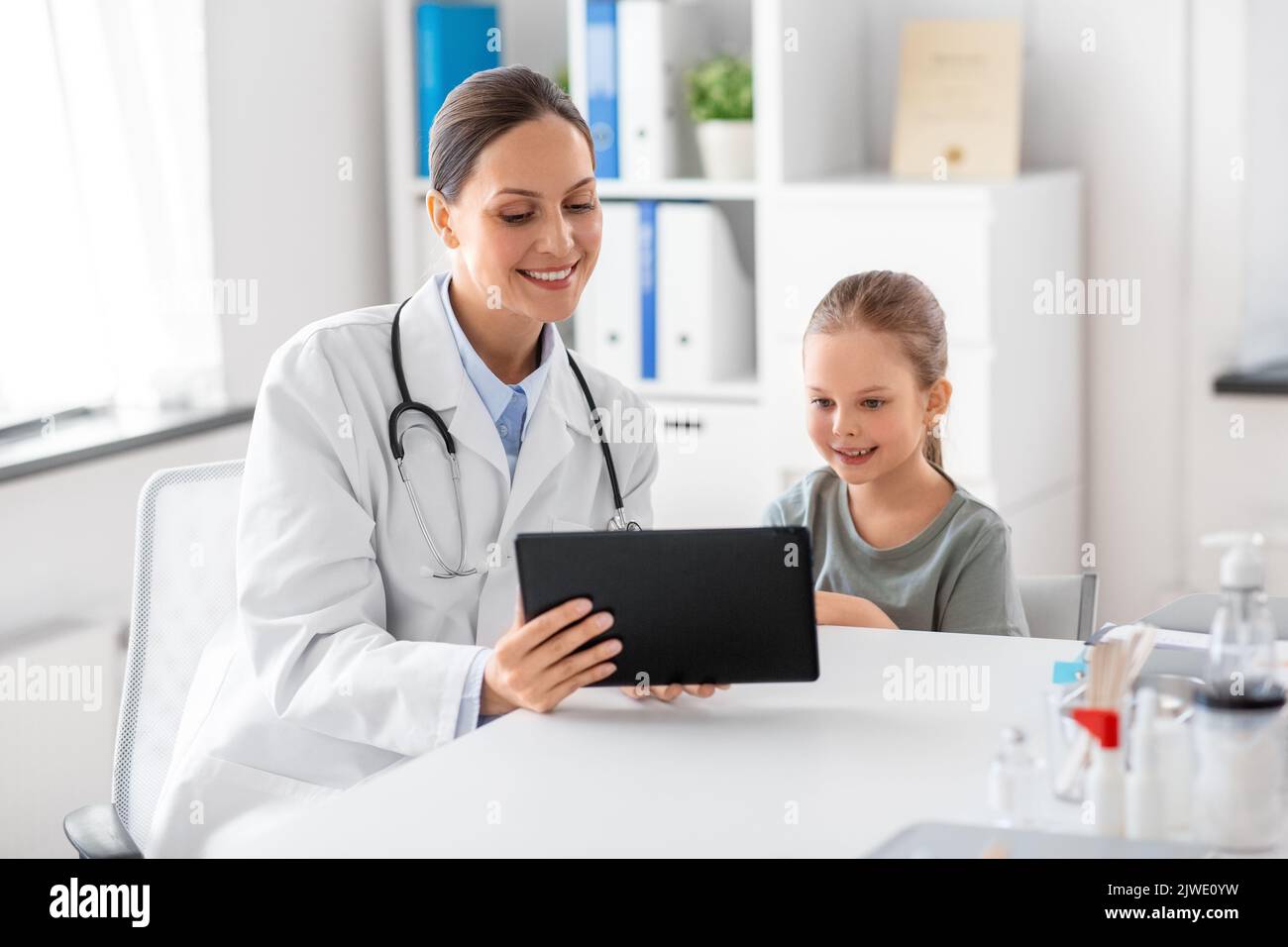 doctor showing tablet pc to little girl at clinic Stock Photo - Alamy