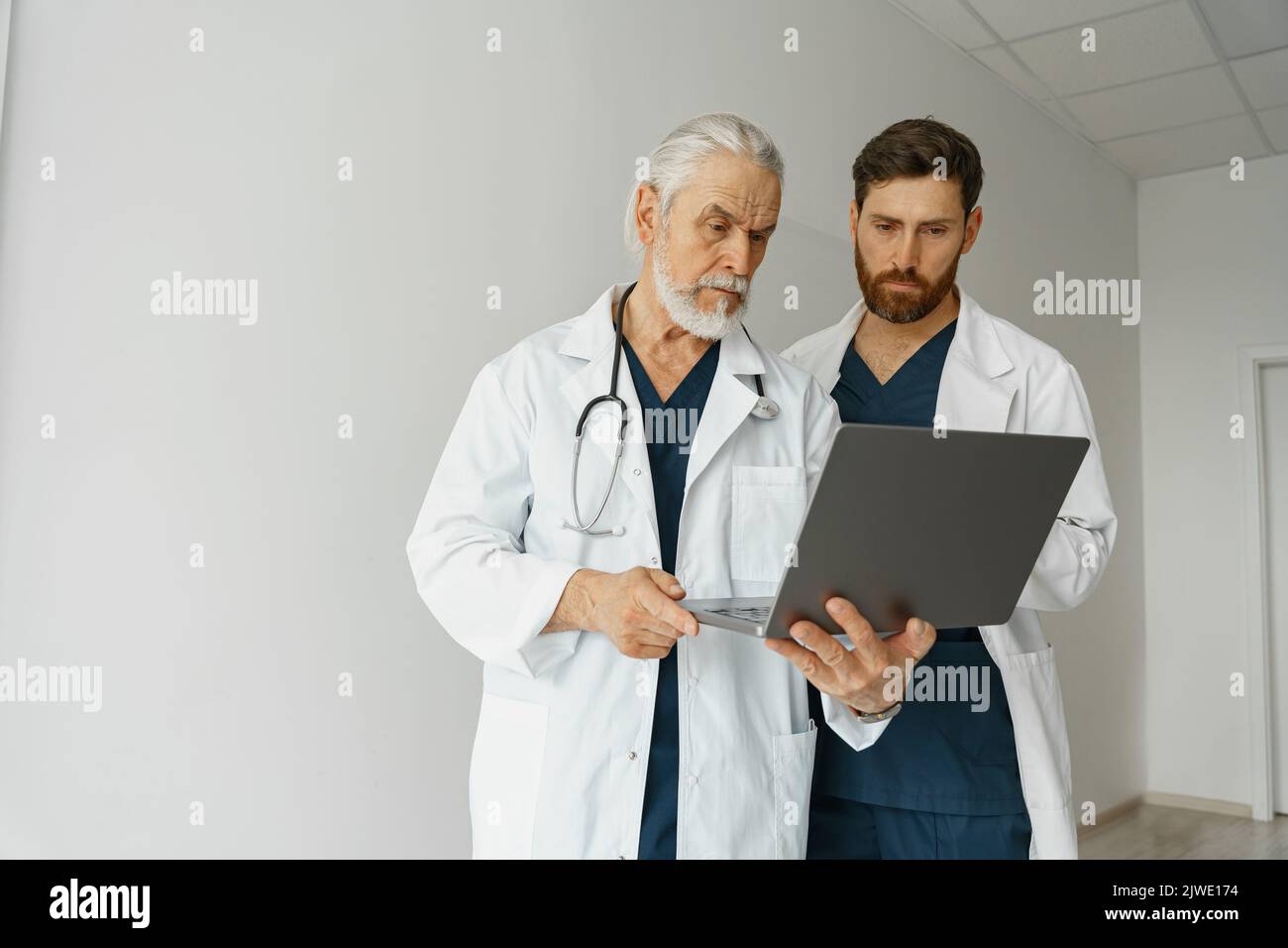 Two doctor colleagues discussing patient diagnosis stand in medicine ...