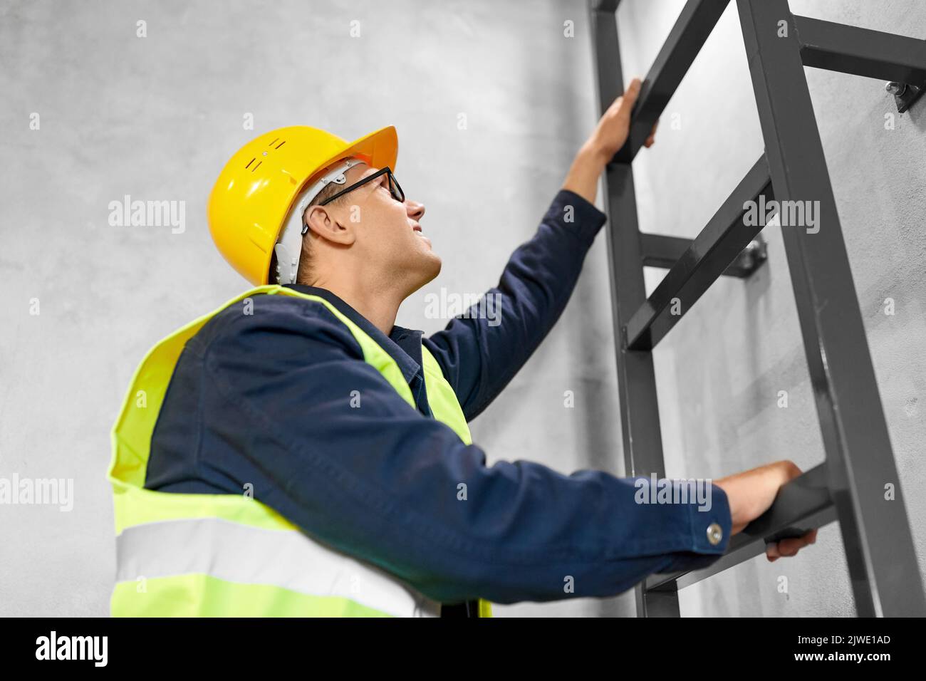 builder or worker in helmet climbing ladder Stock Photo - Alamy