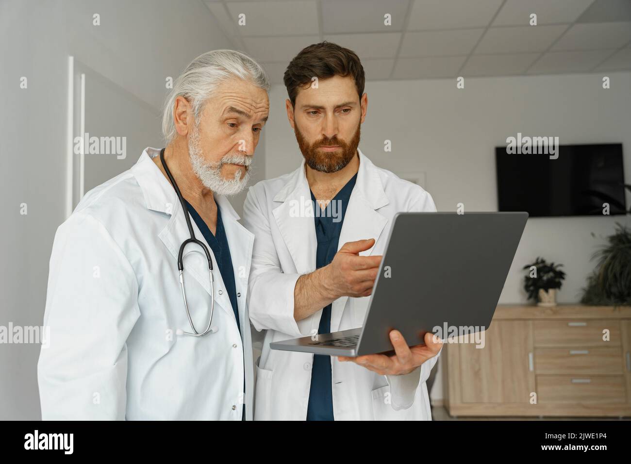 Two doctor colleagues discussing patient diagnosis stand in medicine ...