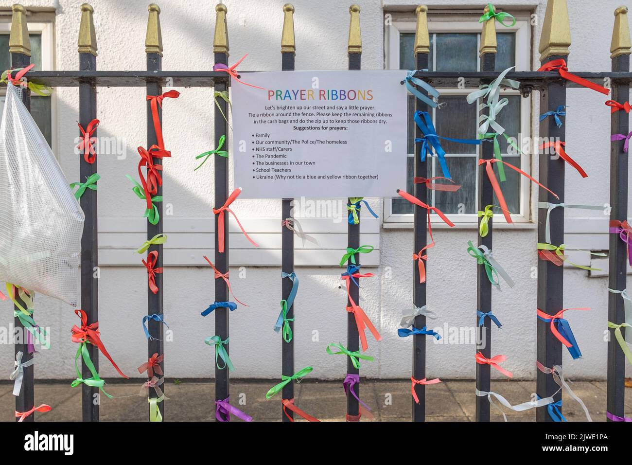 Pray ribbons on metal railings, with sign, outside church in Southend ...