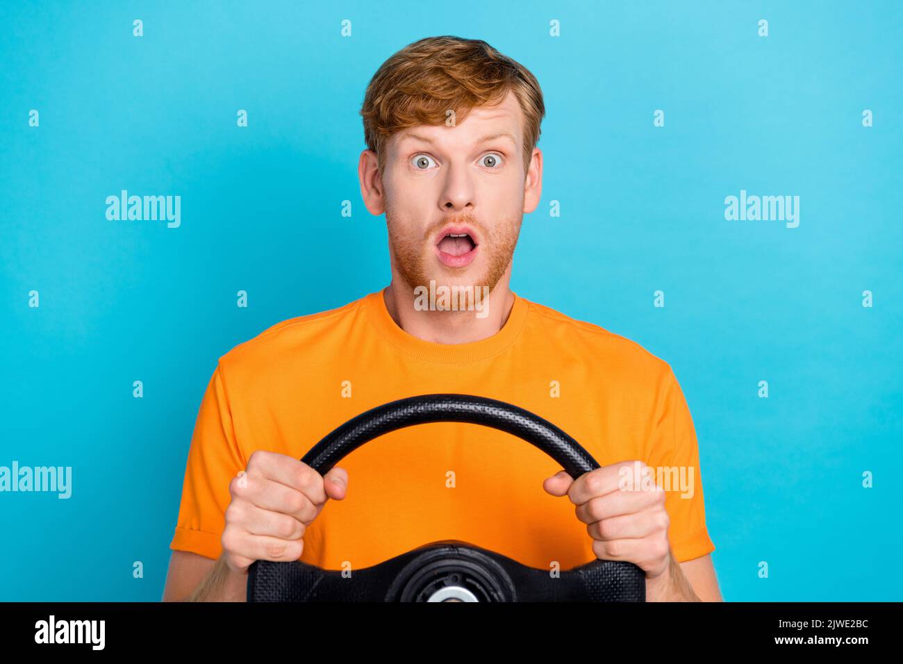 Photo of impressed ginger hair guy drive car wear orange t-shirt ...