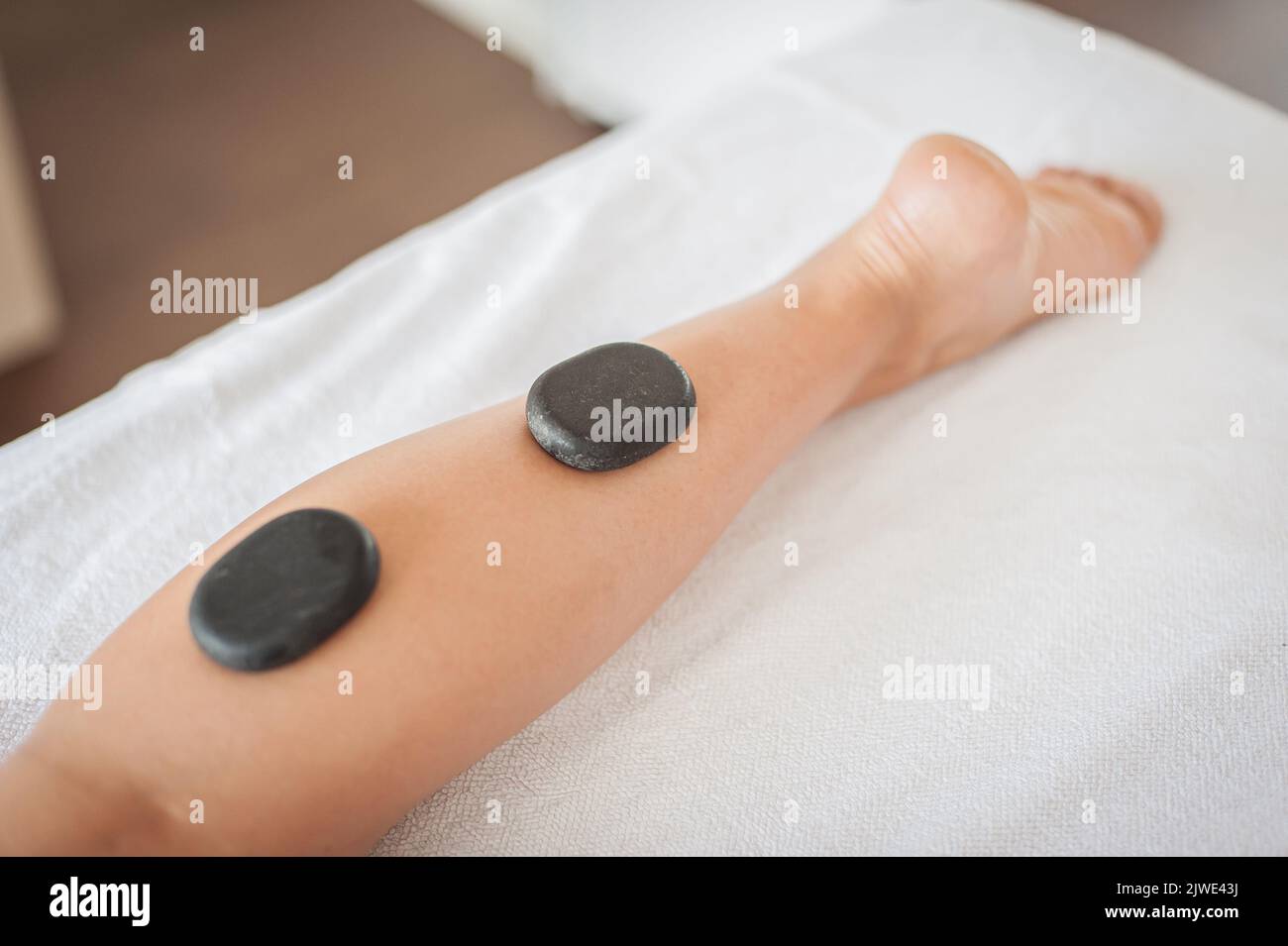 Energy black stones. Woman getting hot spa volcanic lava stone therapy ...