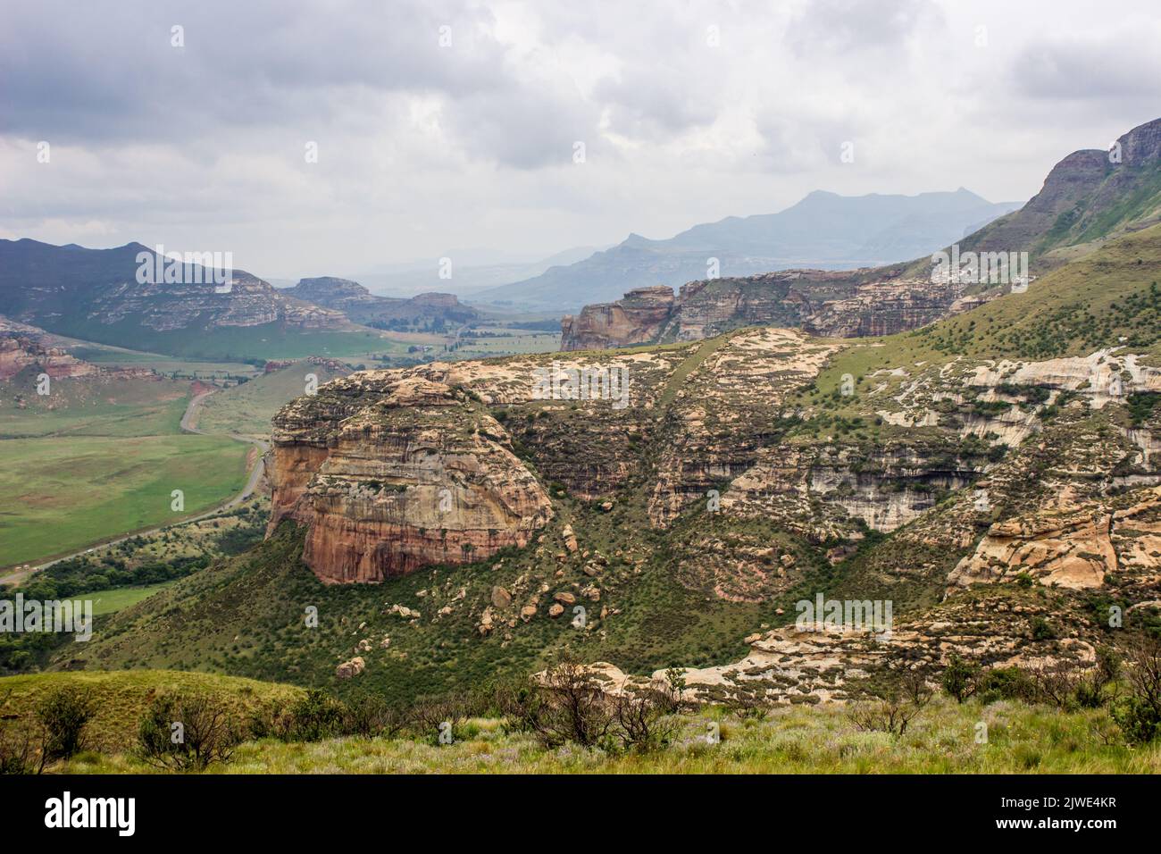 Storm clouds gathering over a valley surrounded by cliffs and distant ...