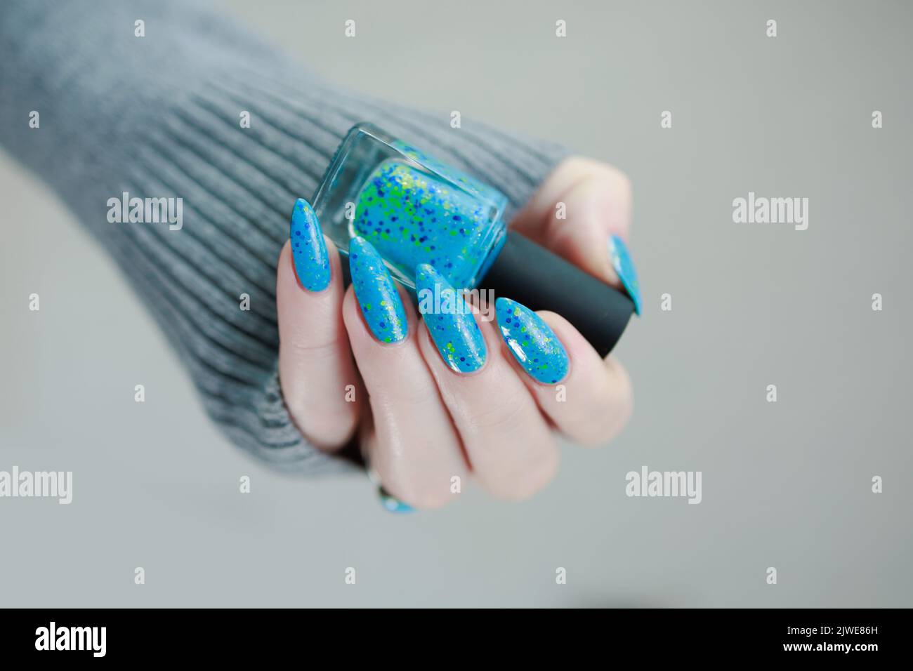 Woman's beautiful hand with long nails and light blue manicure with ...