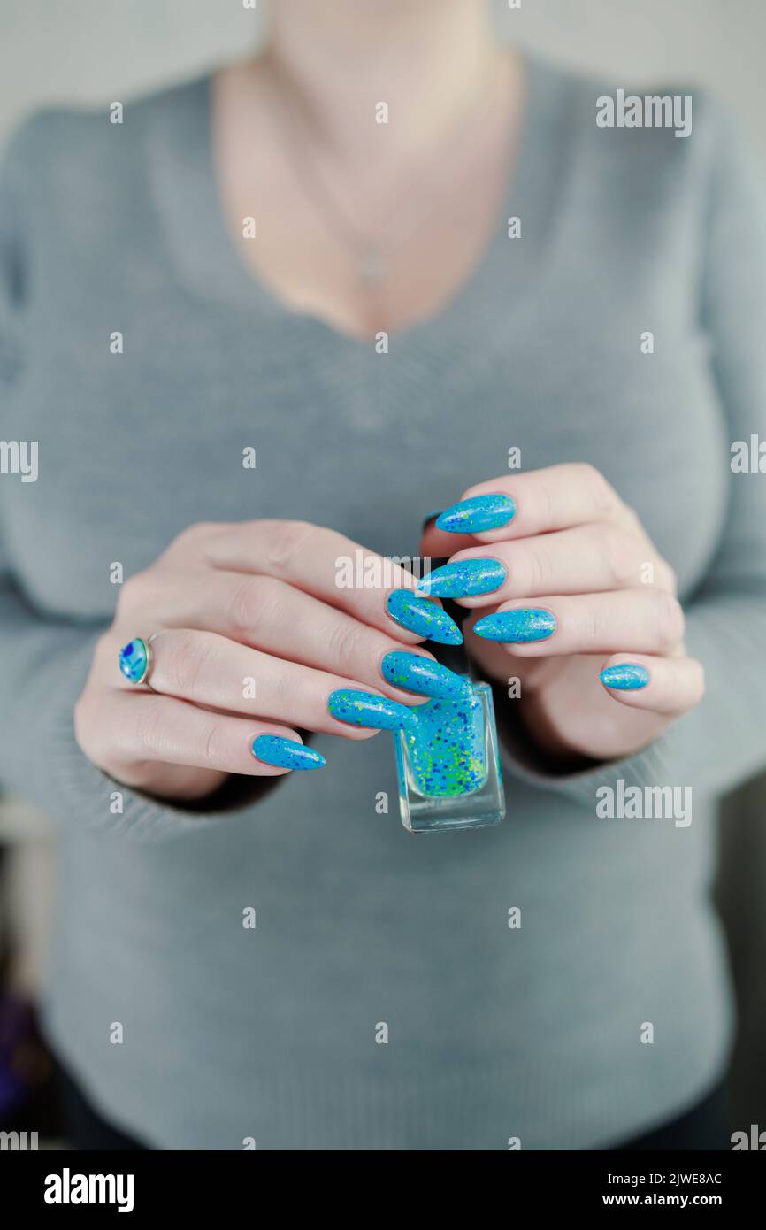 Woman's beautiful hand with long nails and light blue manicure with ...