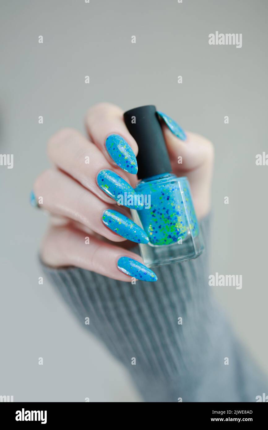 Woman's beautiful hand with long nails and light blue manicure with ...