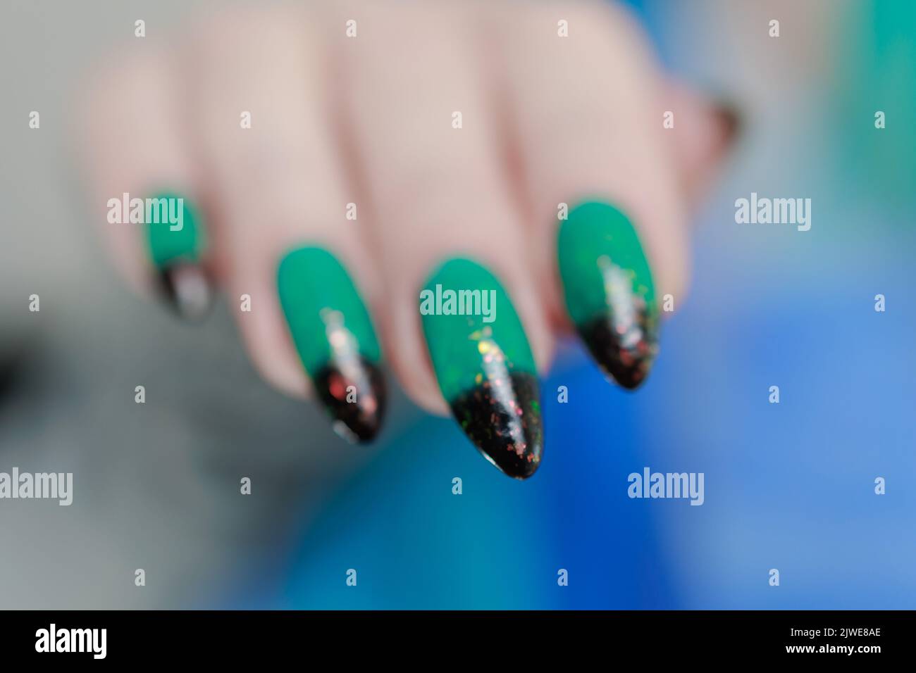 Female hand with long nails and green-black thermo french nail polish ...