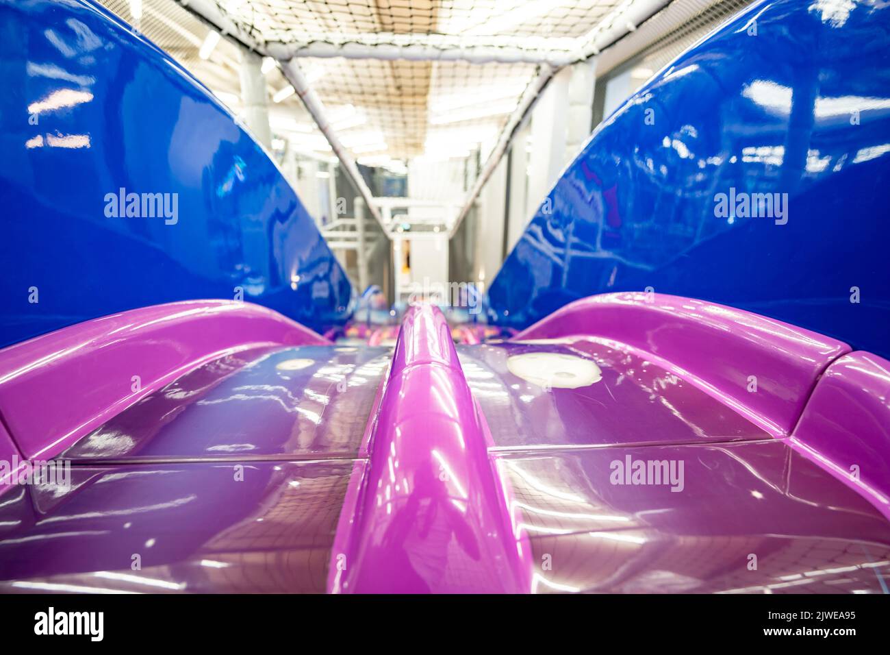 Two parallel purple sliders with blue barriers at playground inside the ...