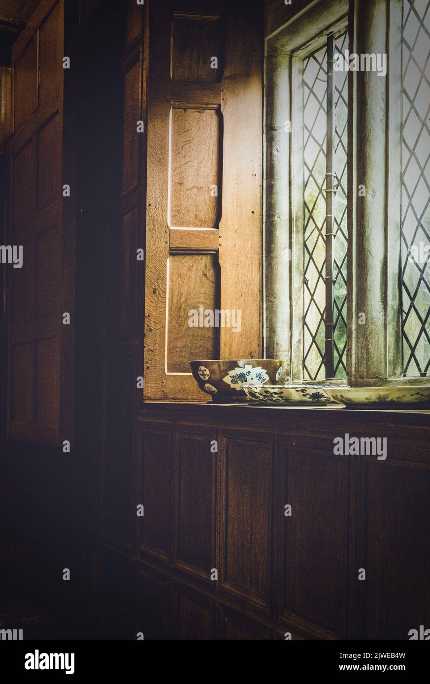 Light shining through leaded window in a wooden panelled room in an ...