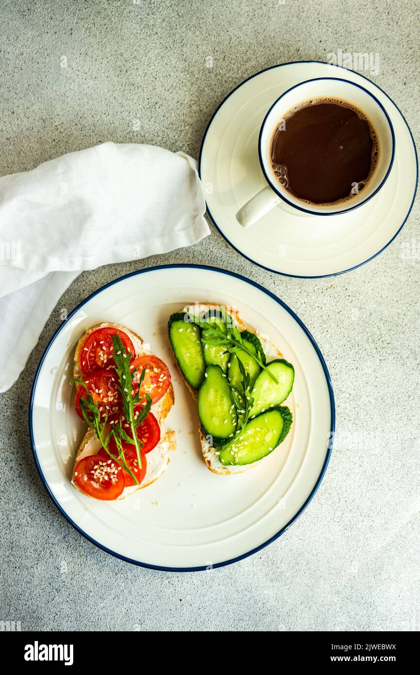 Overhead view of two slices of toast with cream cheese, cucumber ...