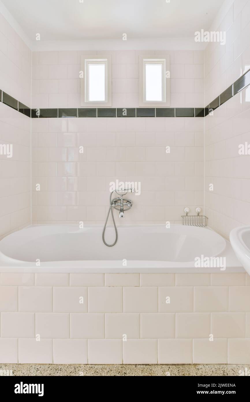 White bathtub with metal faucet in modern bathroom in minimal style in ...