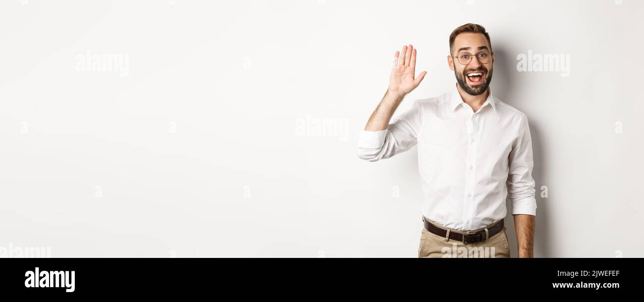 Smiling man standing waving hand hi-res stock photography and images ...