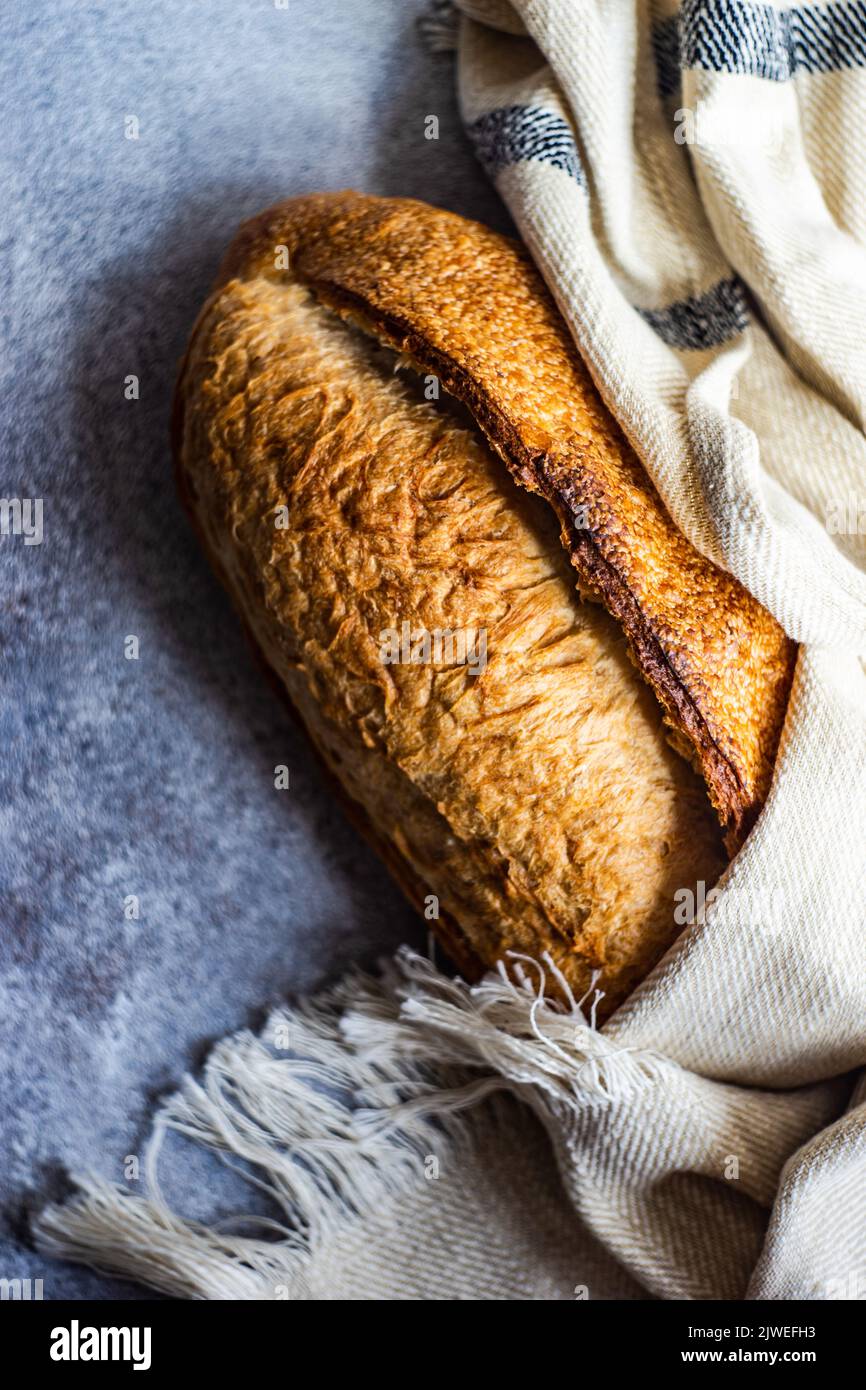 Overhead view of a loaf of sourdough bread on a table with a table ...