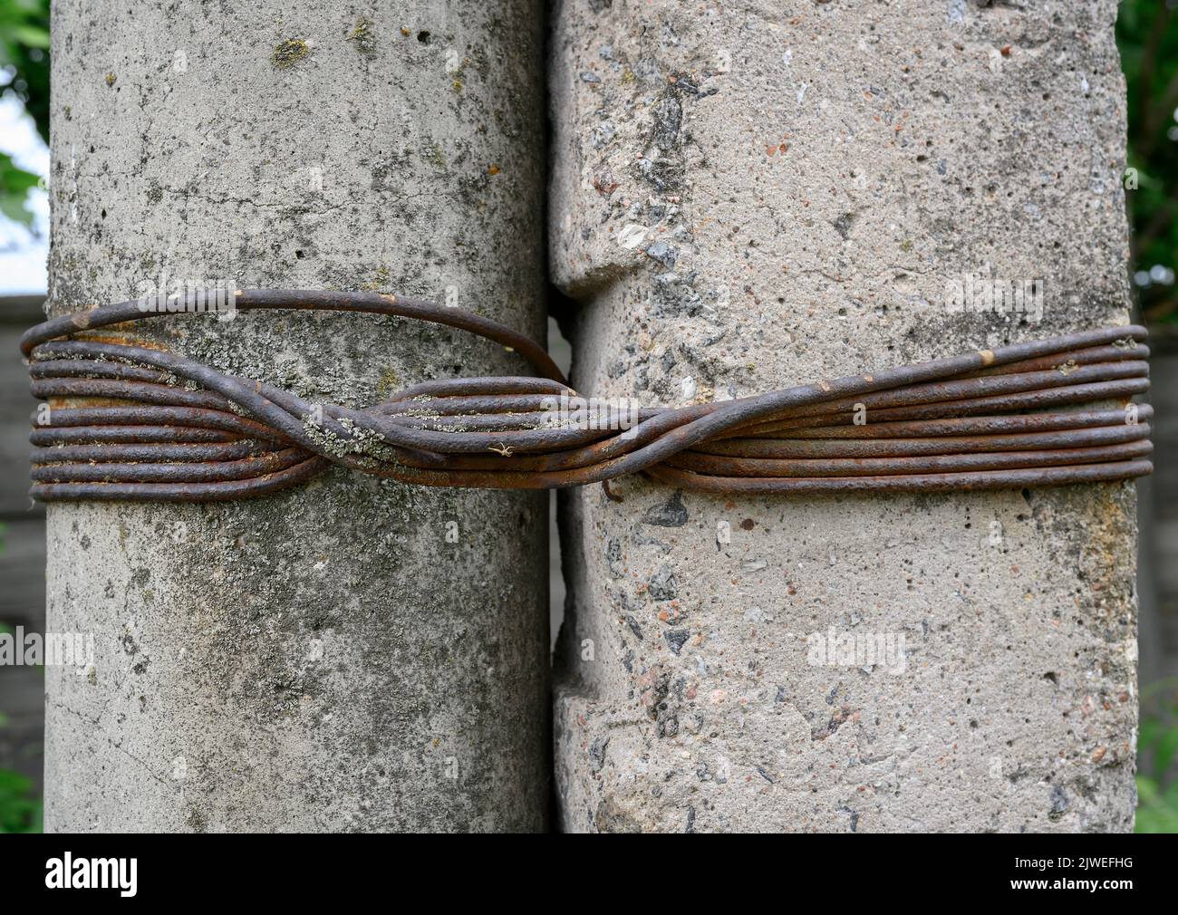 Two concrete pillars tied together with rusty iron wire Stock Photo - Alamy