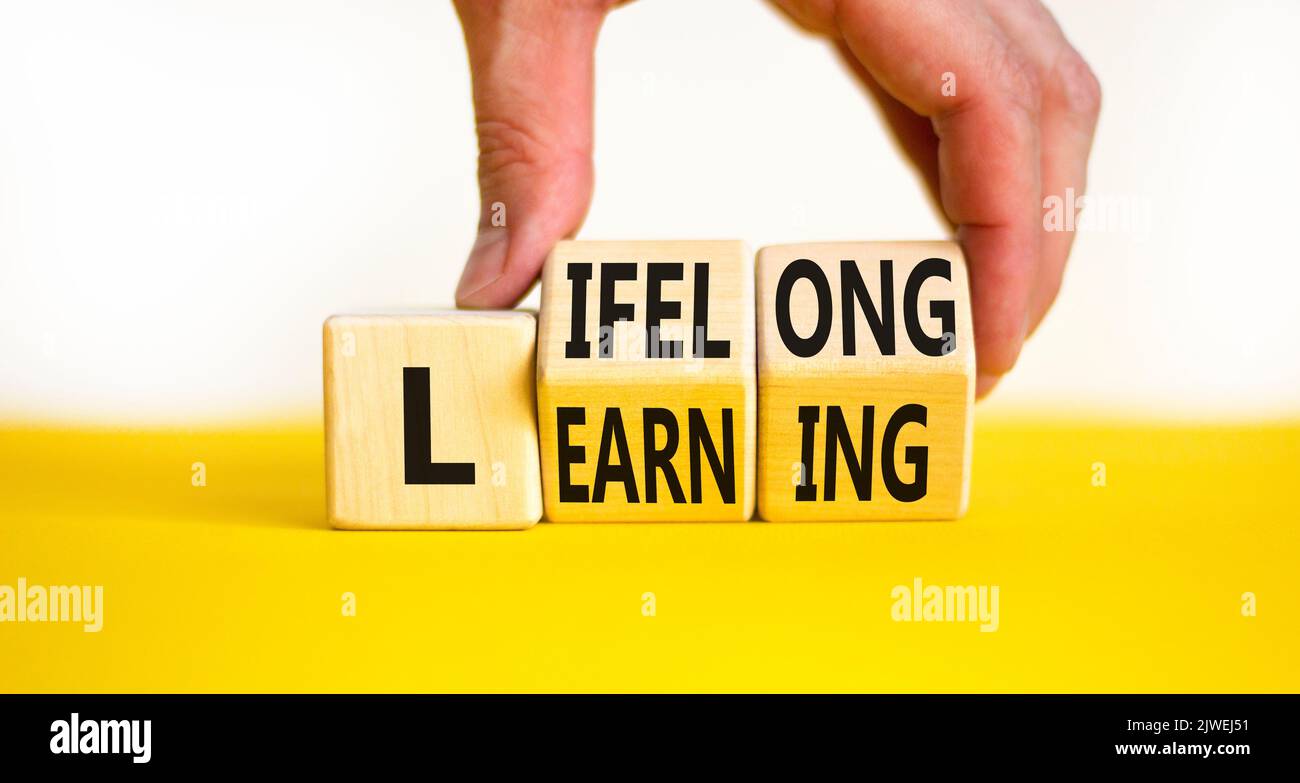 Lifelong learning symbol. Businessman turns wooden cubes with concept ...