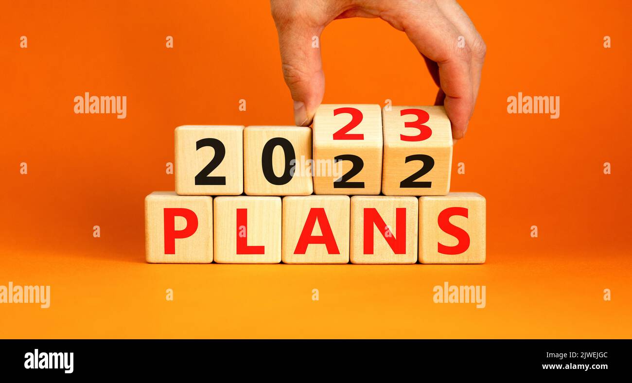 2023 plans new year symbol. Businessman turns a wooden cube and changes ...