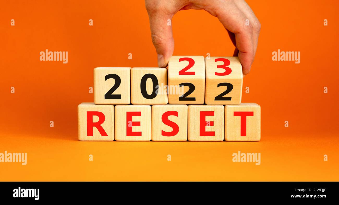 2023 reset new year symbol. Businessman turns a wooden cube and changes ...