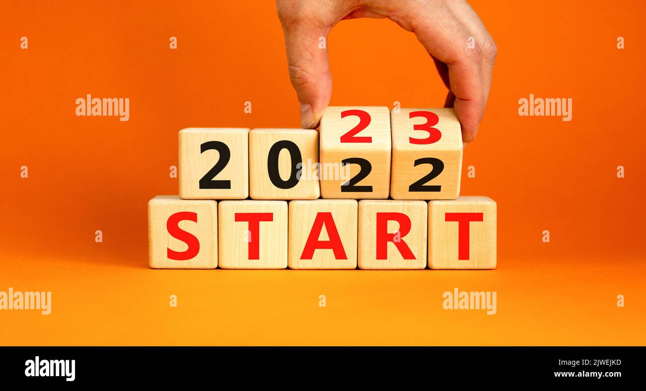 2023 start new year symbol. Businessman turns a wooden cube and changes ...