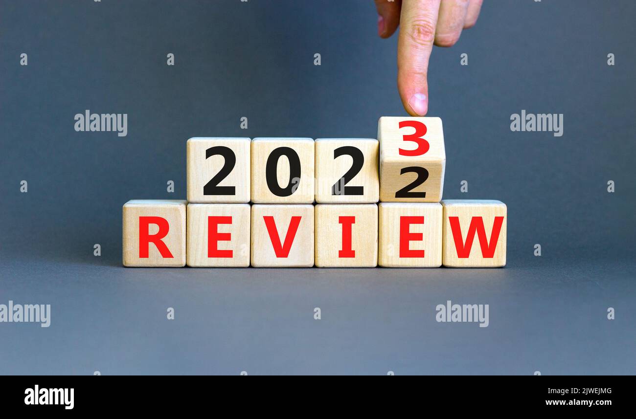 2023 review new year symbol. Businessman turns a wooden cube and ...