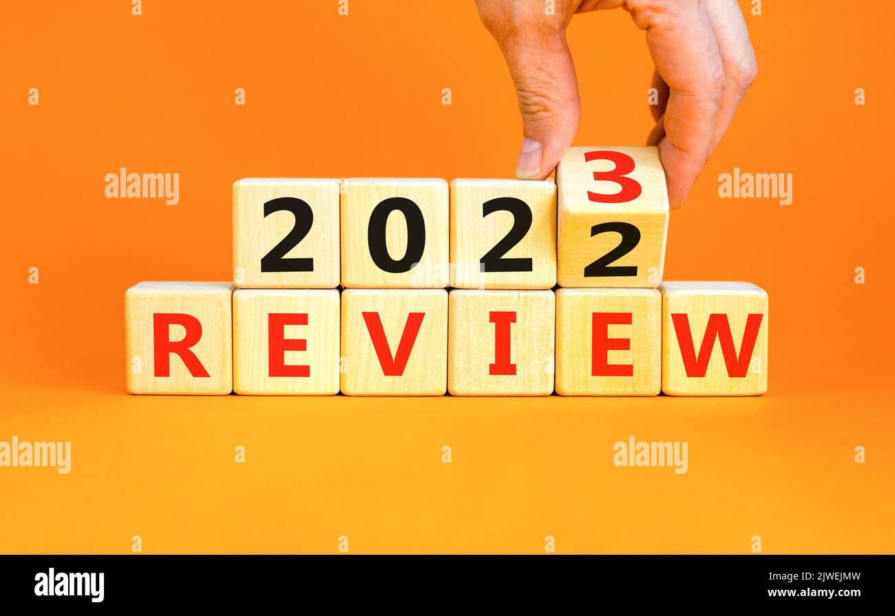 2023 review new year symbol. Businessman turns a wooden cube and ... 2023 review new year symbol. Businessman turns a wooden cube and ...