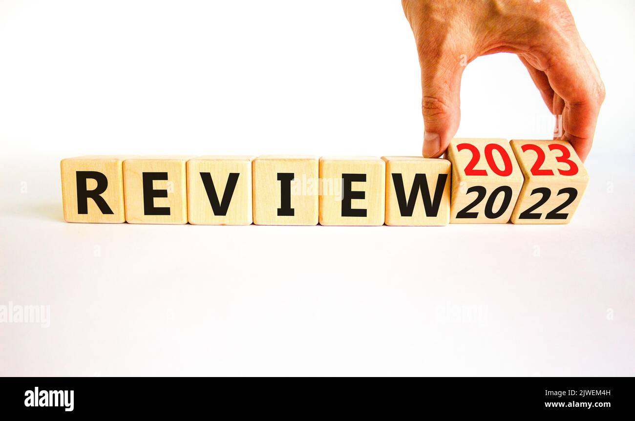 2023 review new year symbol. Businessman turns a wooden cube and ...