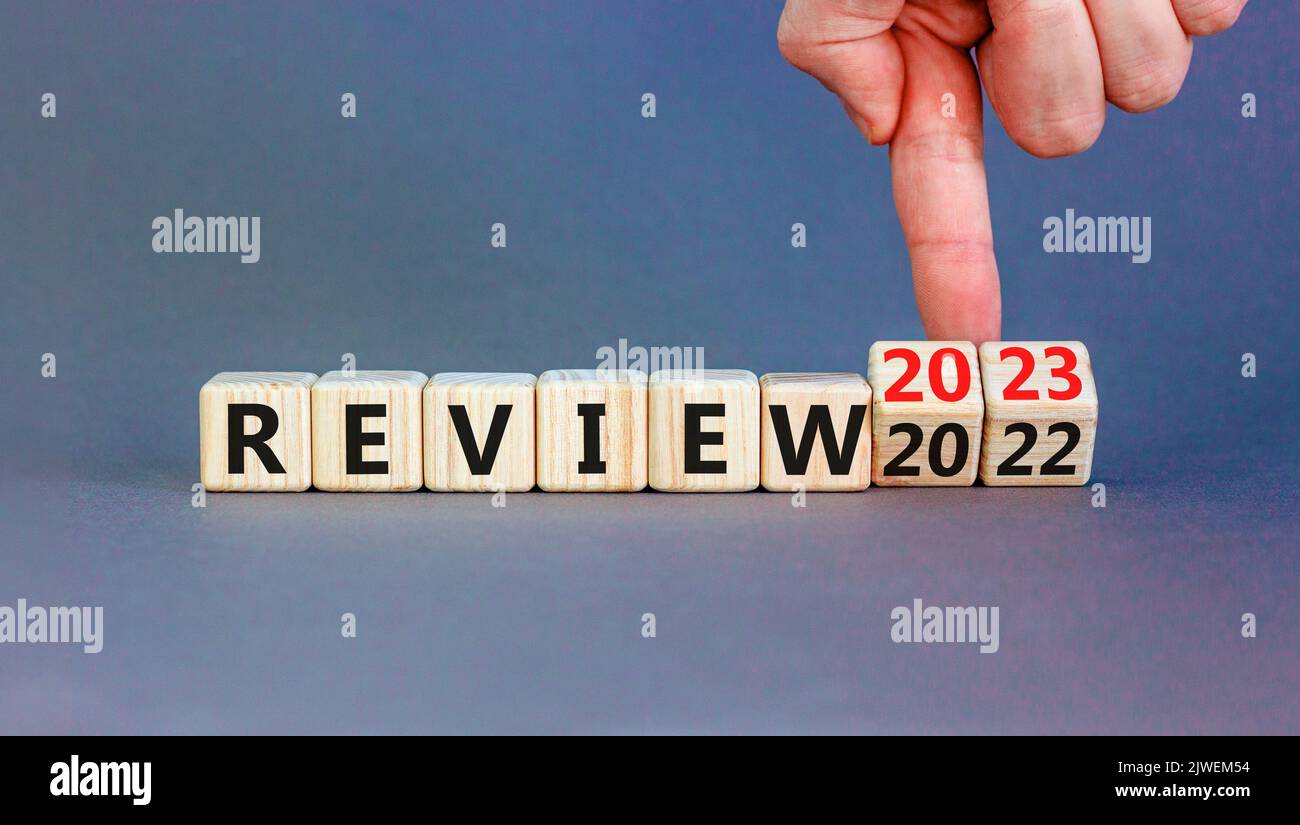 2023 review new year symbol. Businessman turns a wooden cube and ...