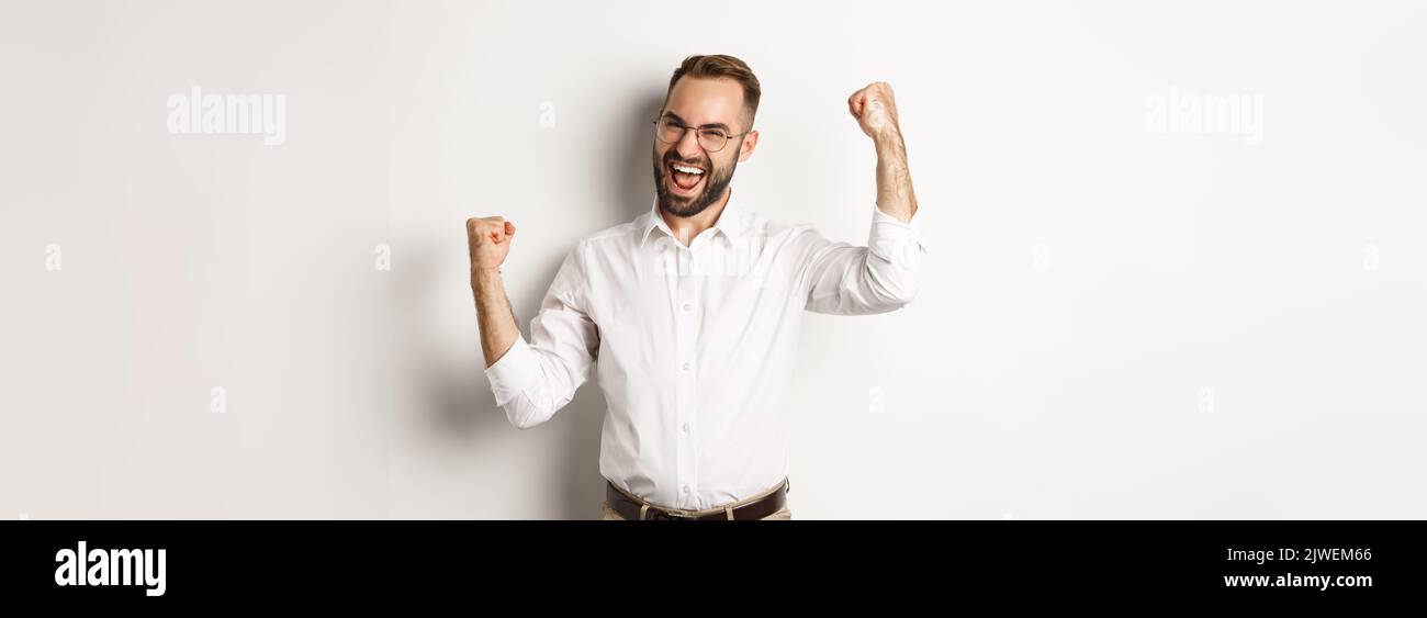 Successful businessman rejoicing, raising hands up and celebrating ...