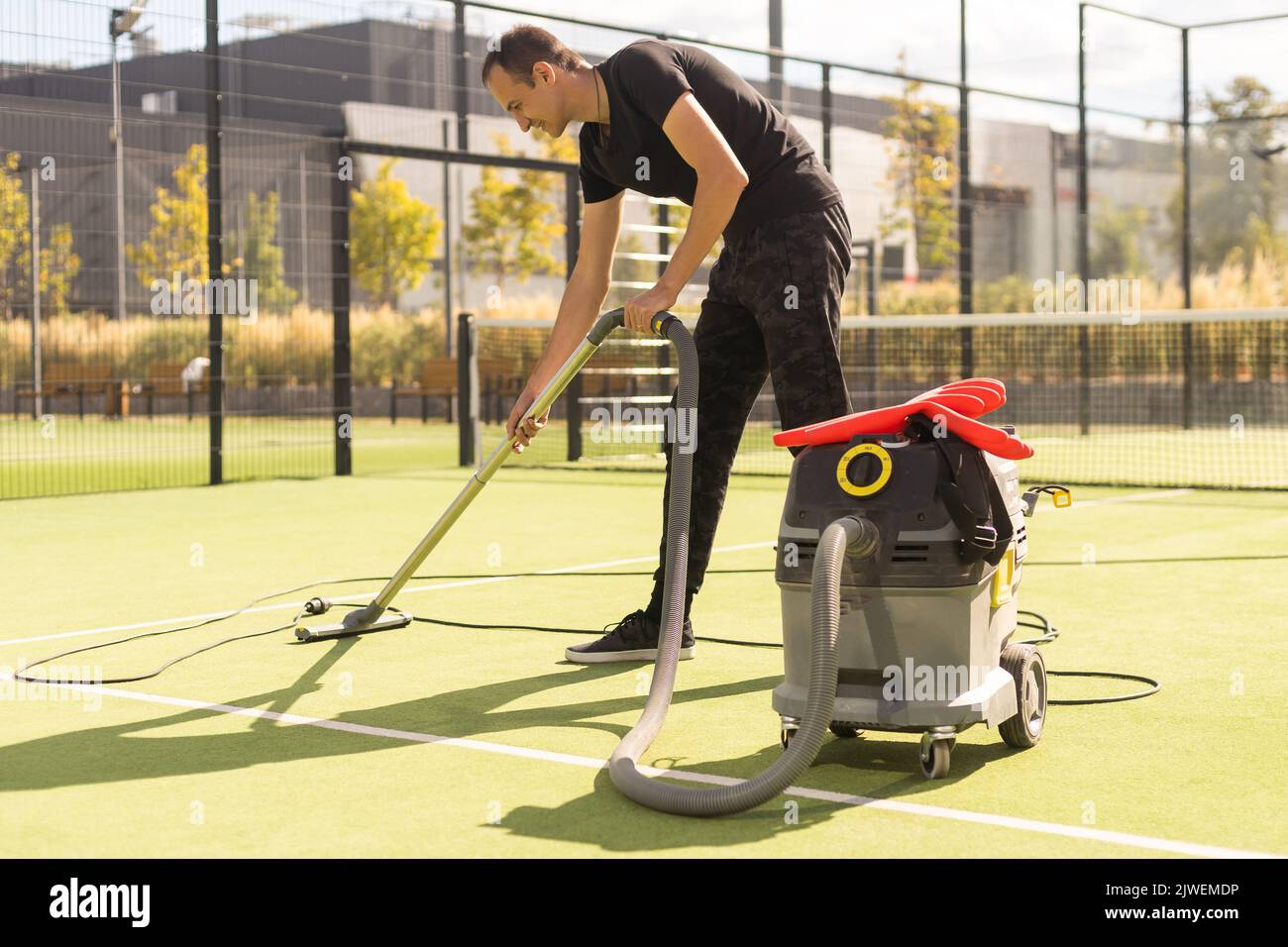 man with vacuum cleaner for the tennis court Stock Photo - Alamy