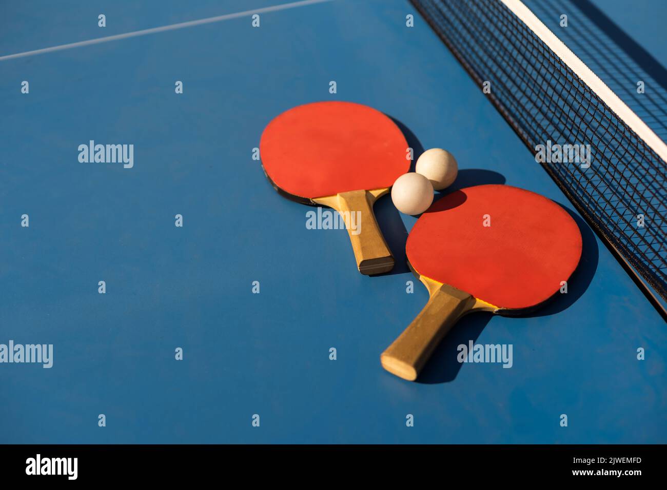 Table tennis ping pong paddles and white ball on blue board Stock Photo ...