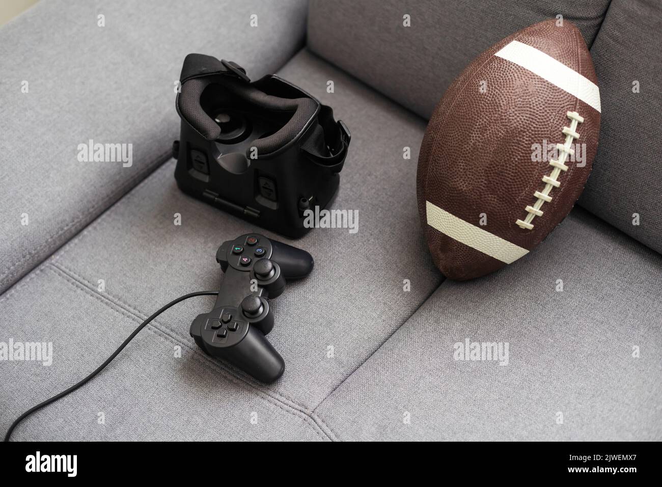 American football ball and game with joystick console Stock Photo - Alamy