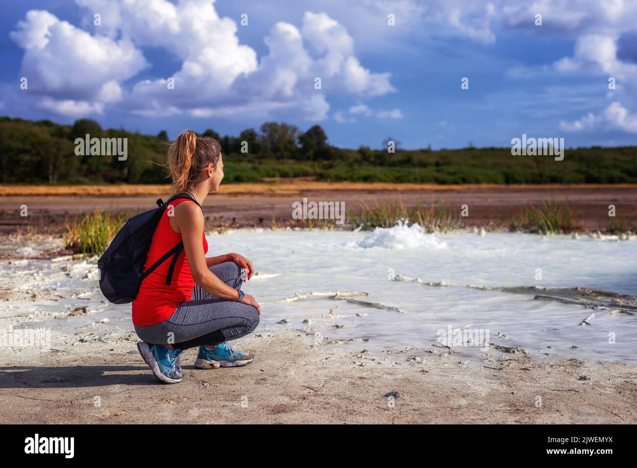 Hiker visits the caldera, a small circular crater with a marsh of ...